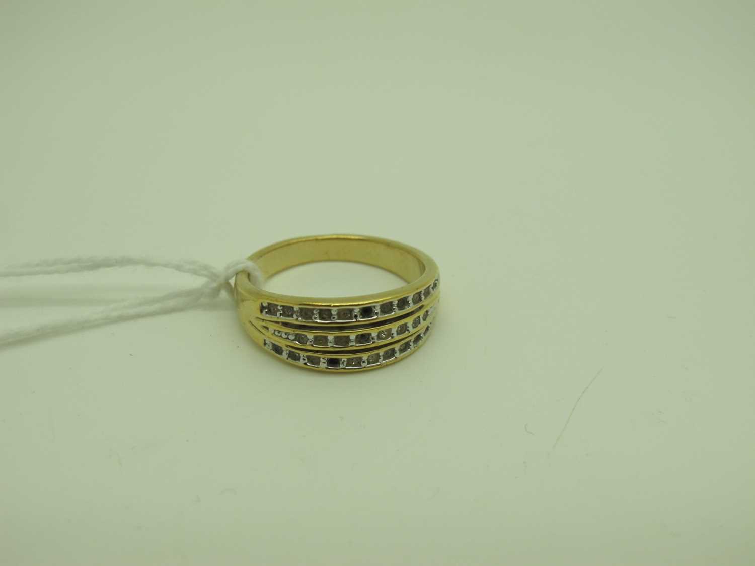 Lot 252 - A Modern Dress Ring, of three row design,