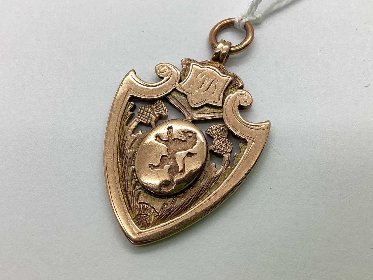 Lot 80 - A 9ct Gold Shield Medallion Fob, of pierced