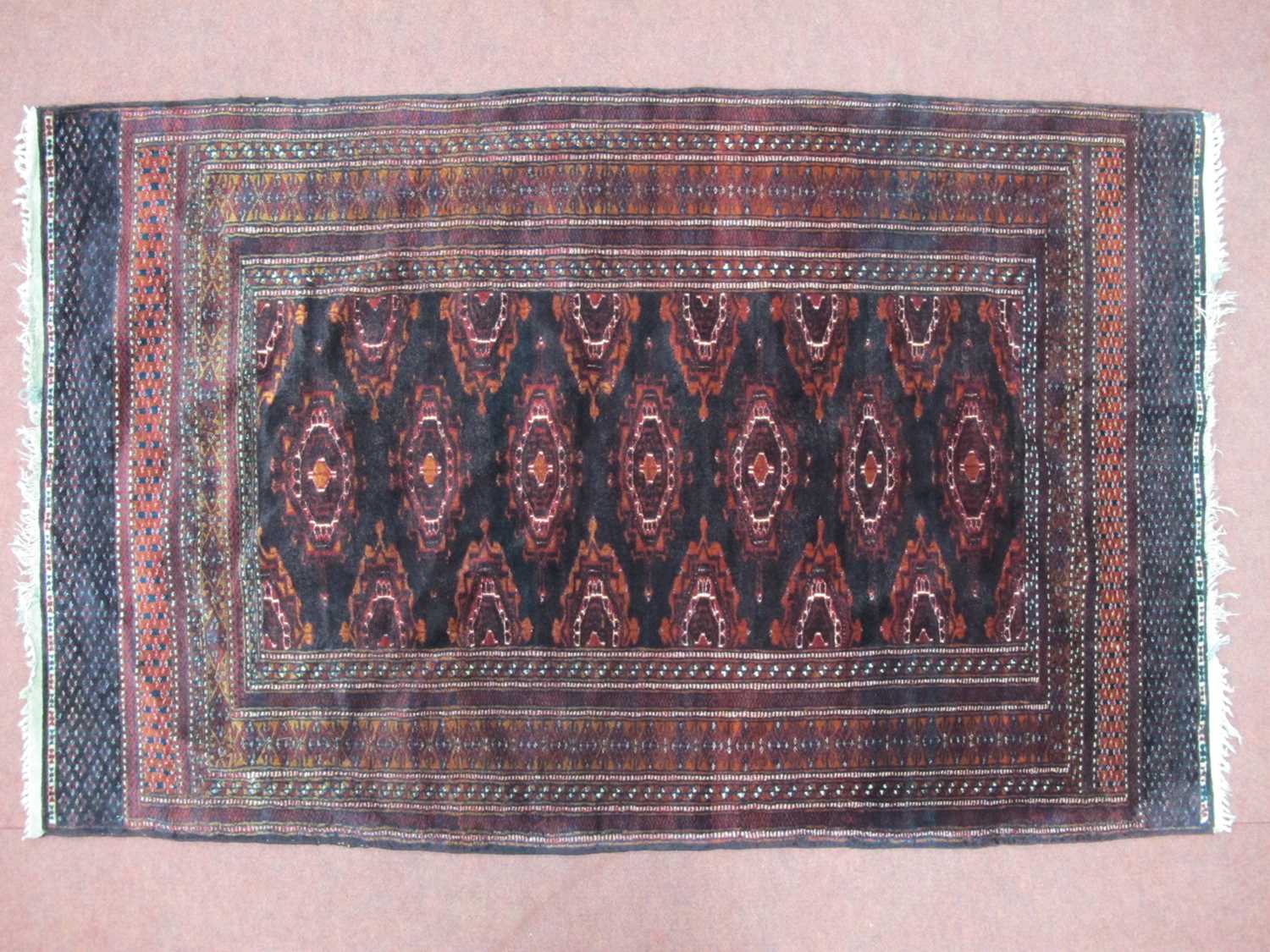 Lot 1547 - A Middle Eastern Rug, in shades of maroon,