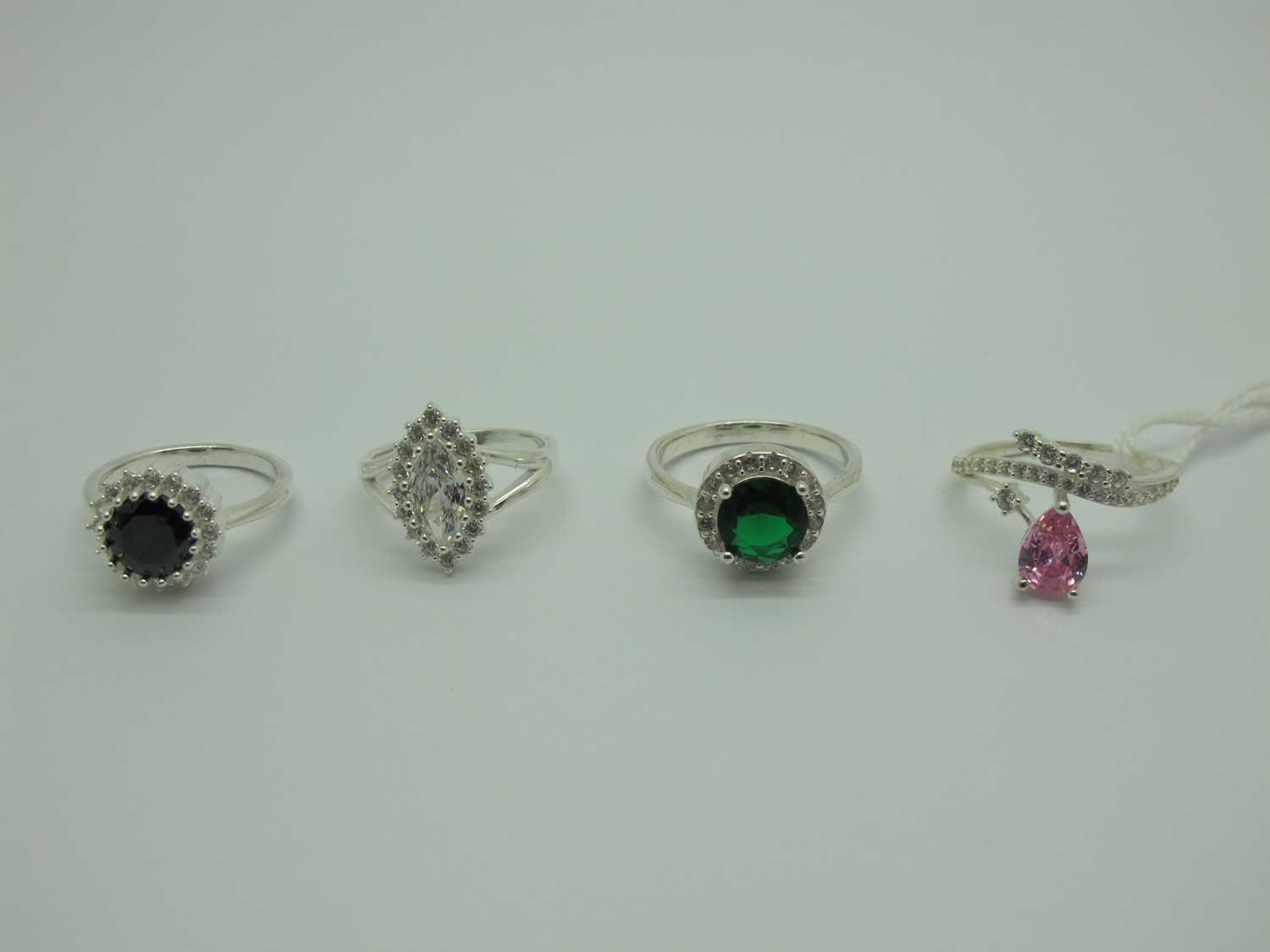 Lot 546 - Four Modern Dress Rings, claw set,